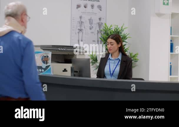 Receptionist and doctor helping old patient with cervical neck collar ...