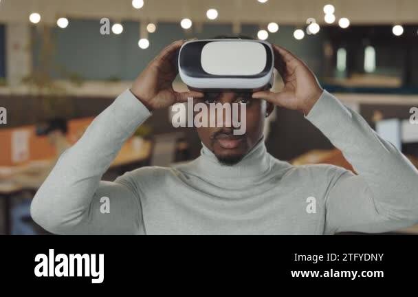 Office male worker wearing a VR headset, virtual reality concept ...