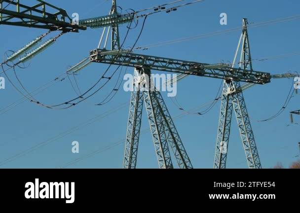 Power lines with sun rays on blue sky. High voltage substation ...