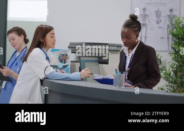 Diverse medical team talking about healthcare insurance and filling in ...