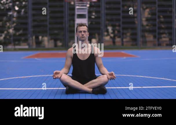 Muscular man sitting in lotus yoga position. Yoga instructor with ...