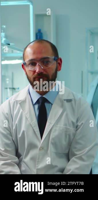 Vertical video: Portrait of exhausted chemist looking at camera in ...