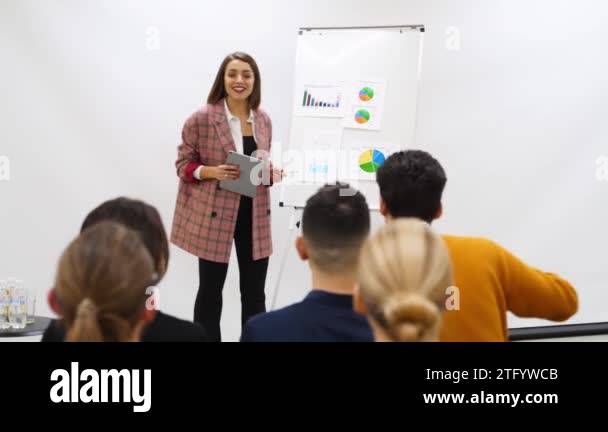 Business woman coach trainer presents report, shows diagrams on flip ... Business woman coach trainer presents report, shows diagrams on flip ...