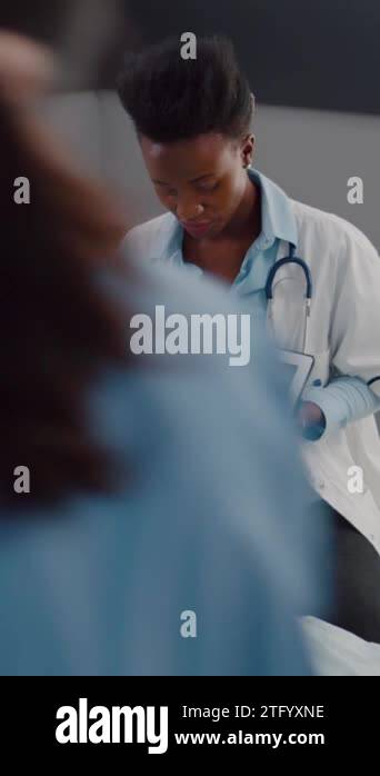 Vertical video: Specialist surgeon black woman doctor explaining ...