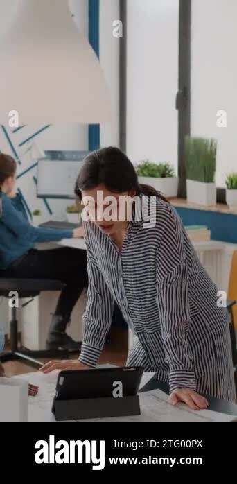 Vertical Video Team Of Architects Working With Blueprints Plans And Tablet To Design Building