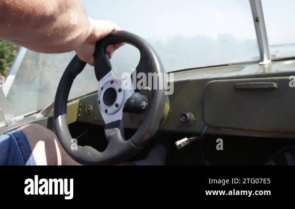 Male hand on rudder, steering wheel of motorboat floating down the ...