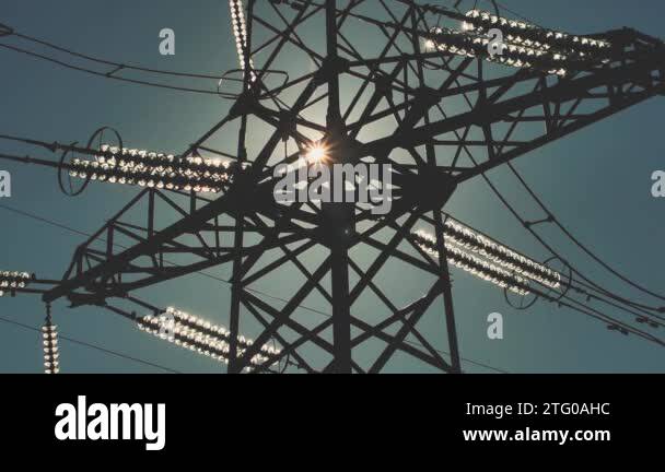 Power lines with sun rays on blue sky. High voltage substation ...