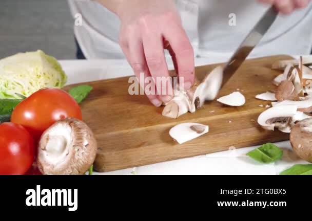 Close-up video of cutting slicing fresh mushrooms. Womans hands cut ...