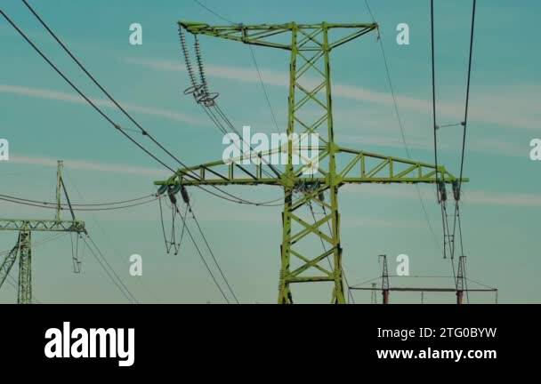 Power lines with sun rays on blue sky. High voltage substation ...