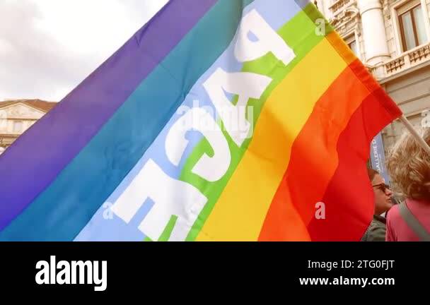 People with peace rainbow flags waving in slow motion at a ...