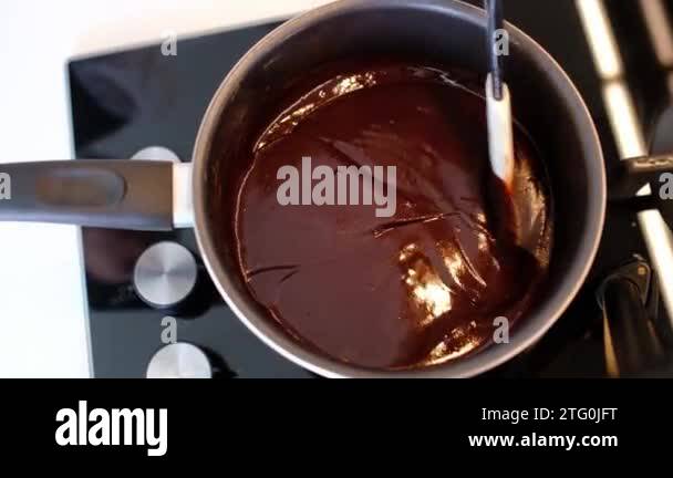 Melting and mixing a piece of butter in a saucepan on the gas stove ...