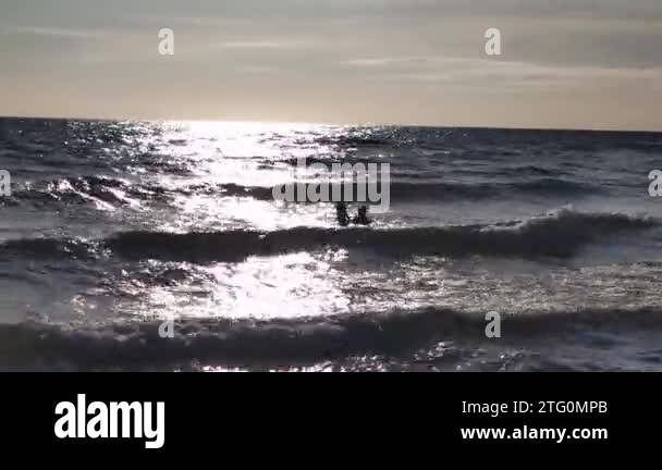 Two kids on the beach, in the maritime wave. Two boys on playing in the ...