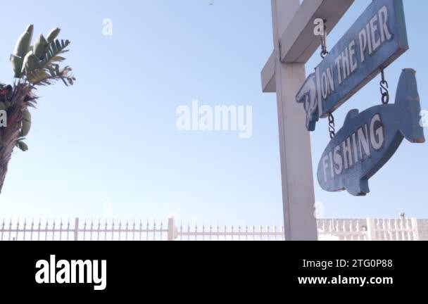 Fishing on pier wooden blue sign, California ocean beach, USA. Coast ...