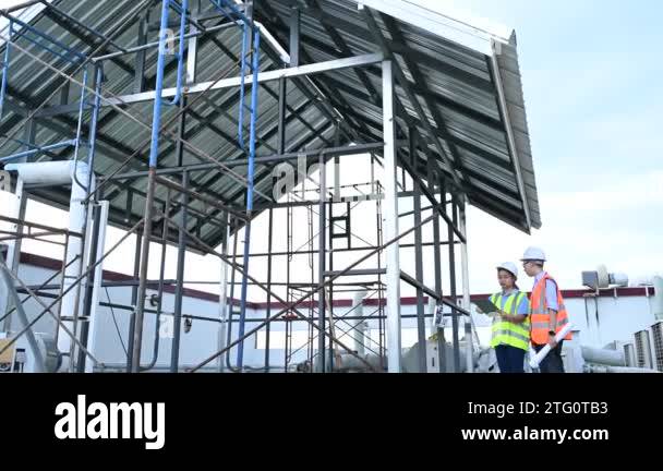 Young engineers working. Plan for construction of a warehouse. See the ...