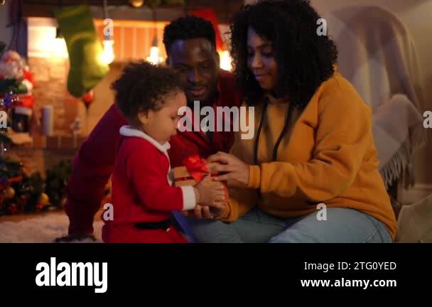 Curios little boy man and woman opening Christmas gift box with light ...