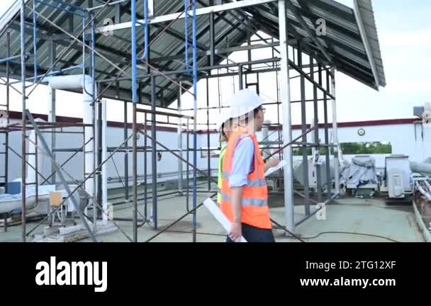 Young engineers working. Plan for construction of a warehouse. See the ...