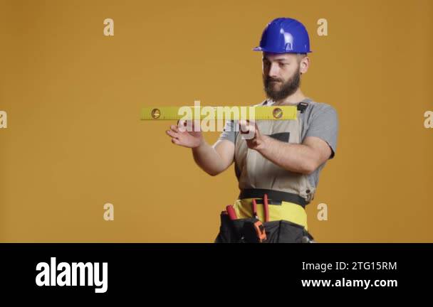 Construction builder working with water level tool to do measurement ...