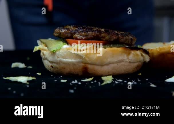 Slow motion shot of layered hamburger making, burger menu image with ...