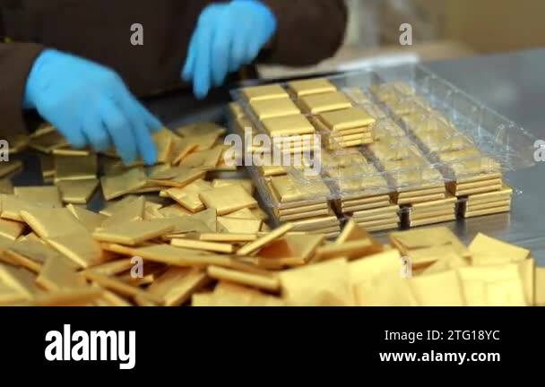 Rows of toppings for chocolates manufactured by machine, on a conveyor ...