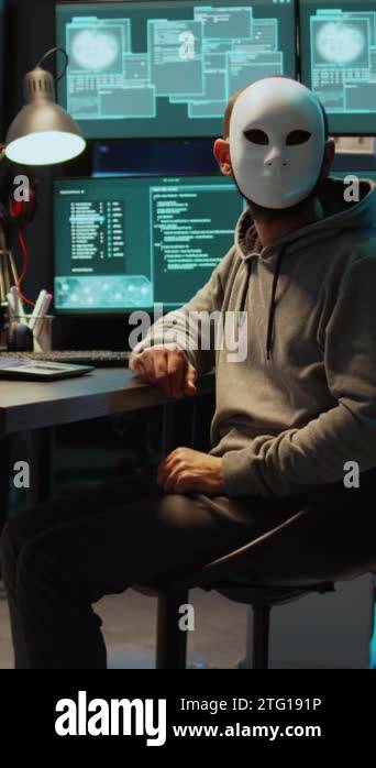 Vertical video: Web terrorist wearing mask hacking database servers, hacker with hood breaking ...