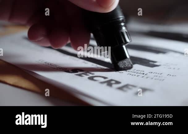 Black marker drawing black lines on top secret paper before being ...
