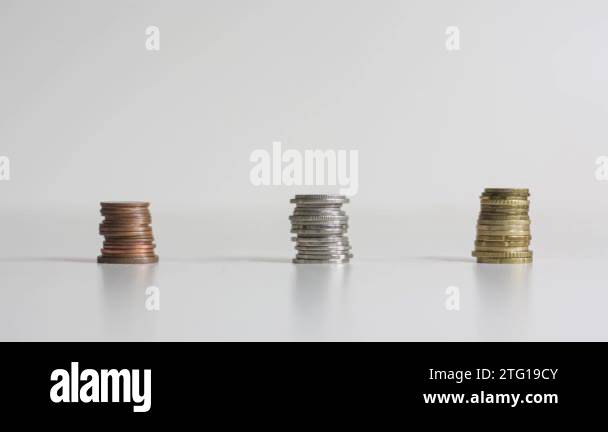 Three rising and falling stacks of copper, silver and golden coins on a ...