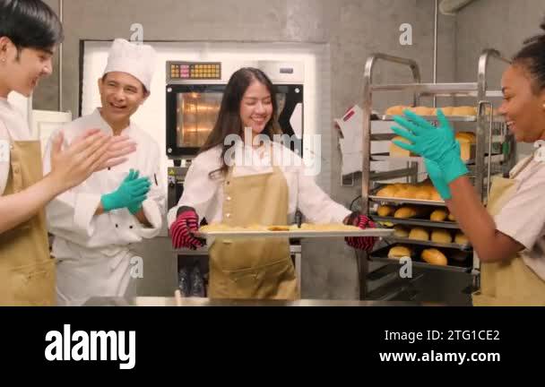 Young Asian female cooking class student brings tray of baked pies from ...