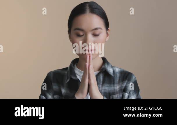 Close up portrait asian calm girl folds palms in front bows namaste ...