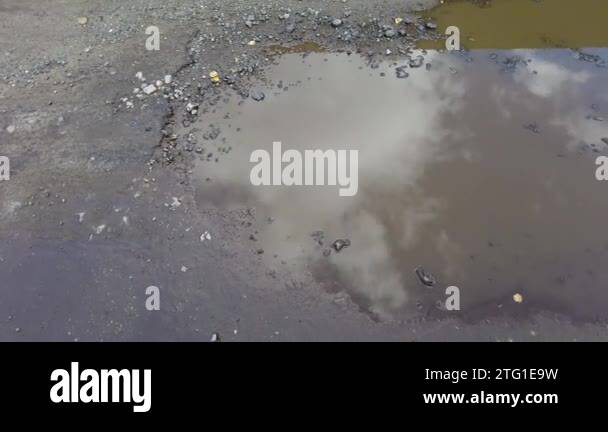 the sky is reflected in a puddle. big puddle on the road. Raindrops ...