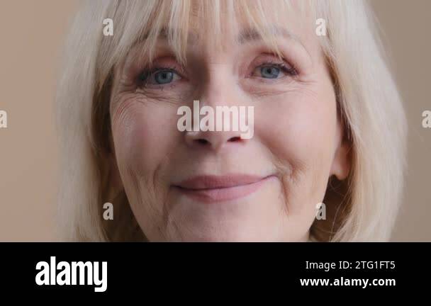 Close up wrinkled female face portrait smiling mature grey-haired ...
