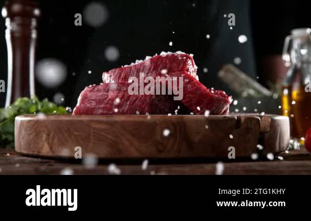 Super slow motion of falling spices on beef steak. Filmed on high speed ...