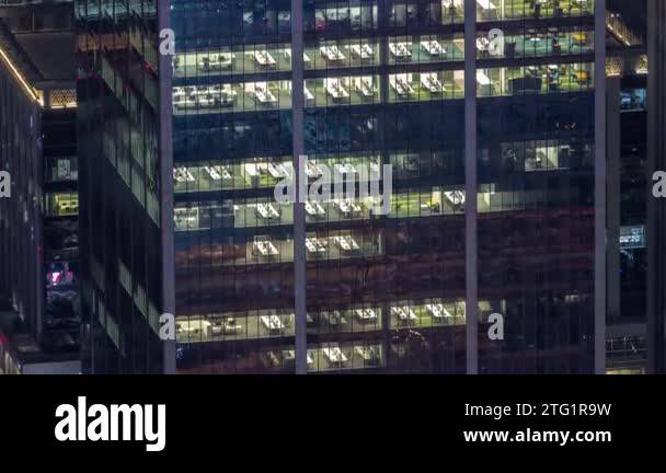 Illuminated panoramic windows in offices of a high class building at ...