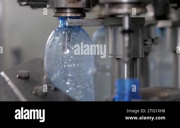 Close-up of pouring water into a plastic bottle with a volume of 0.5 ...