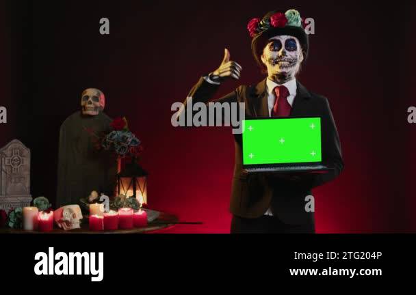 Mexican lady of death showing greenscreen template on laptop, smiling ...