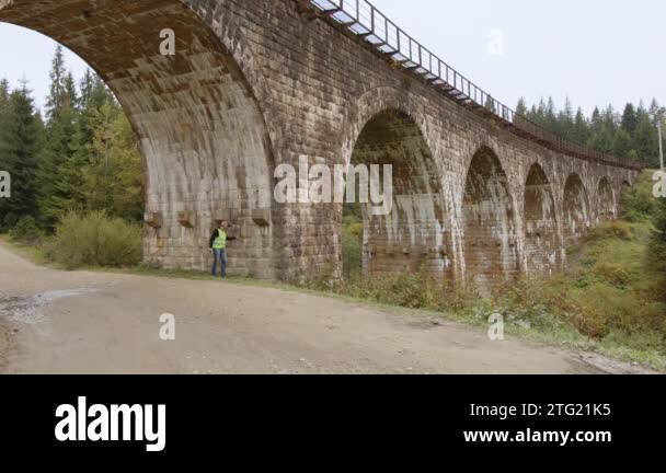 Inspection of bridges. A senior gray-haired engineer stands under a ...