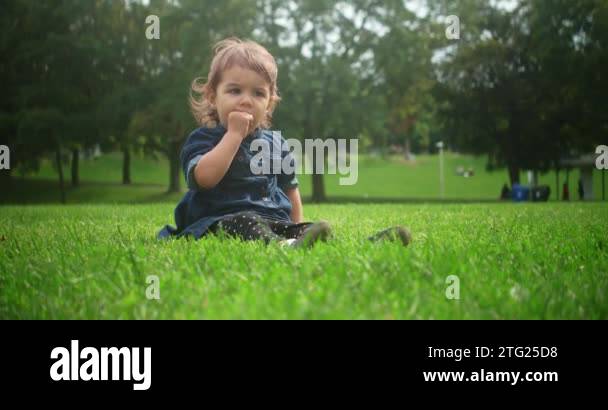 Cute baby girl exploring a park in summer. Real life, candid footage ...