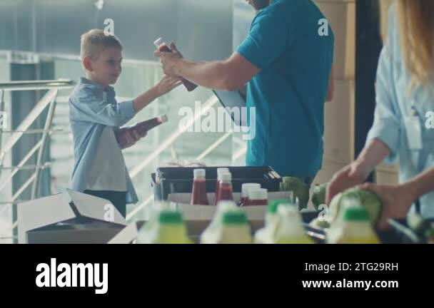 The Concept of Social Aid: Cute Young Boy Help to Volunteers to Sorting ...
