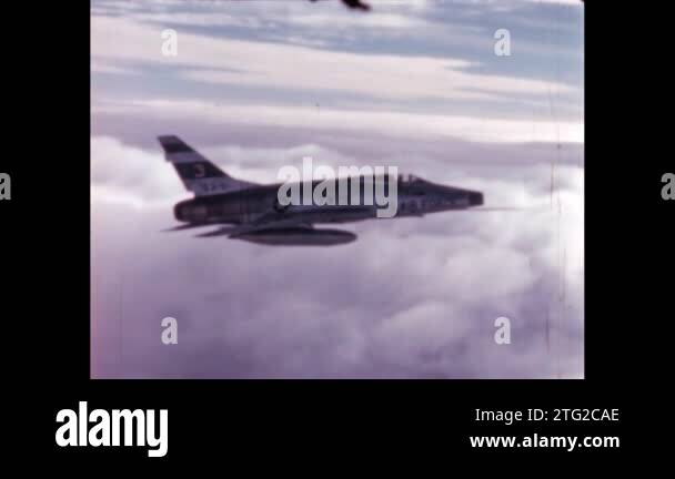 Military supersonic interceptor of 1950s in flight over the clouds ...