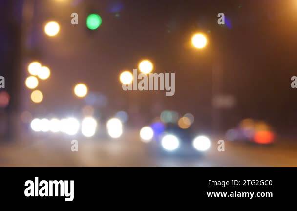 Cars passing on red traffic light signal. Out of focus background with blurry unfocused city ...