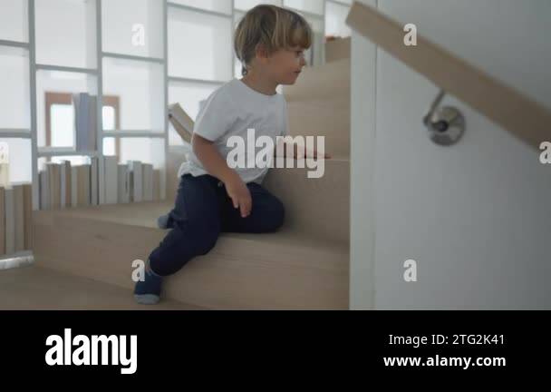 Child going up the staircases at home. One little boy climbing stairs ...