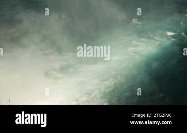 Strong waterfall stream lit by sun. Huge waterfall flows into sea Stock ...