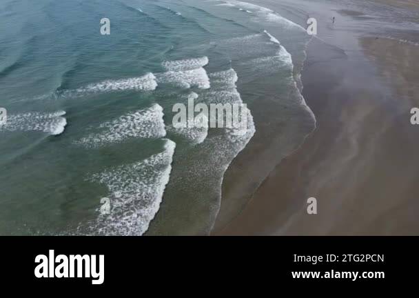 A deserted beach with wet sand and beautiful tidal waves. White sea ...