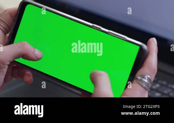 girl holding the phone vertically clicks on the green screen of the phone green screen ...