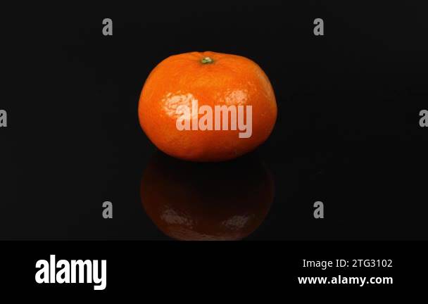 spinning orange fruit on the black background, citrus on the black ...