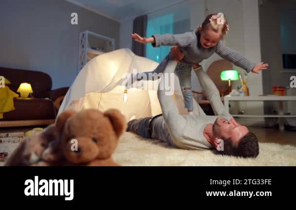 Happy daughter imitating flying in father hands and hugging parent ...