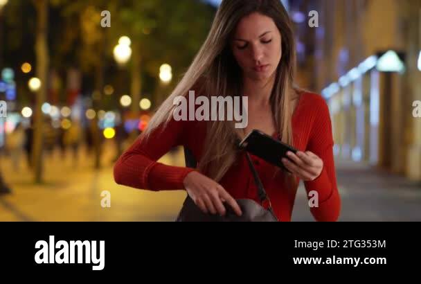 Young woman taking phone out of purse to send text standing on Paris ...