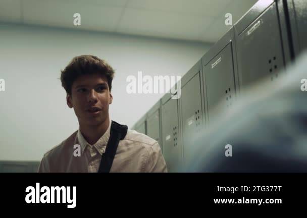 Pretty indian boy standing at lockers school corridor closeup. Brunet ...