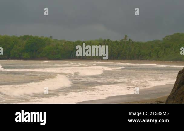 STILL SHOT: Tropical beach in rainy weather with muddy ocean ripple ...