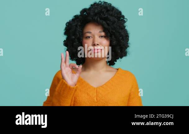 Beautiful African American woman with curly hair looking unconvinced ...