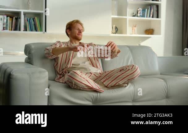 Serene guy breathing air relaxing at cozy home. Satisfied ginger man ...